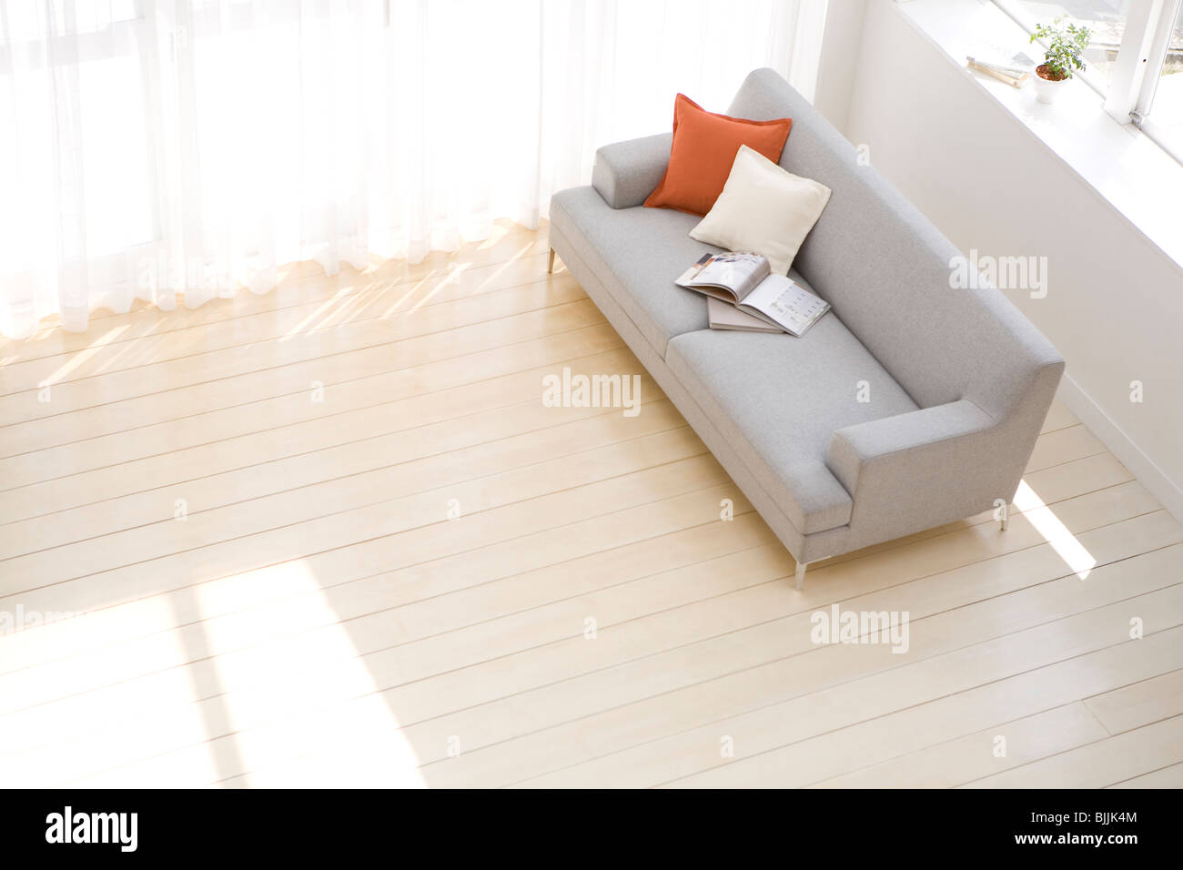 Books on sofa in living room Stock Photo - Alamy
