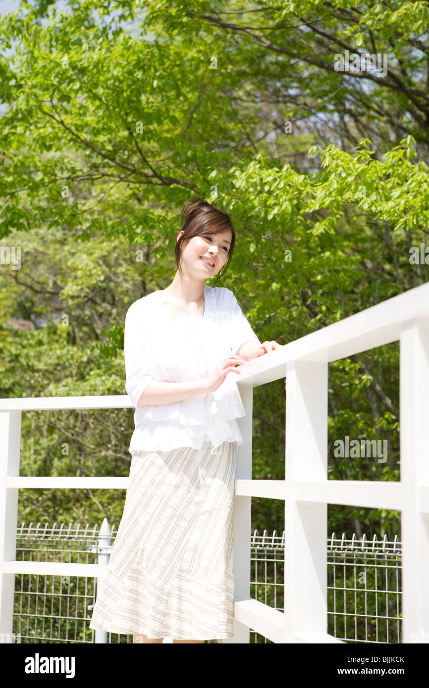 Woman leaning against a railing Stock Photo - Alamy