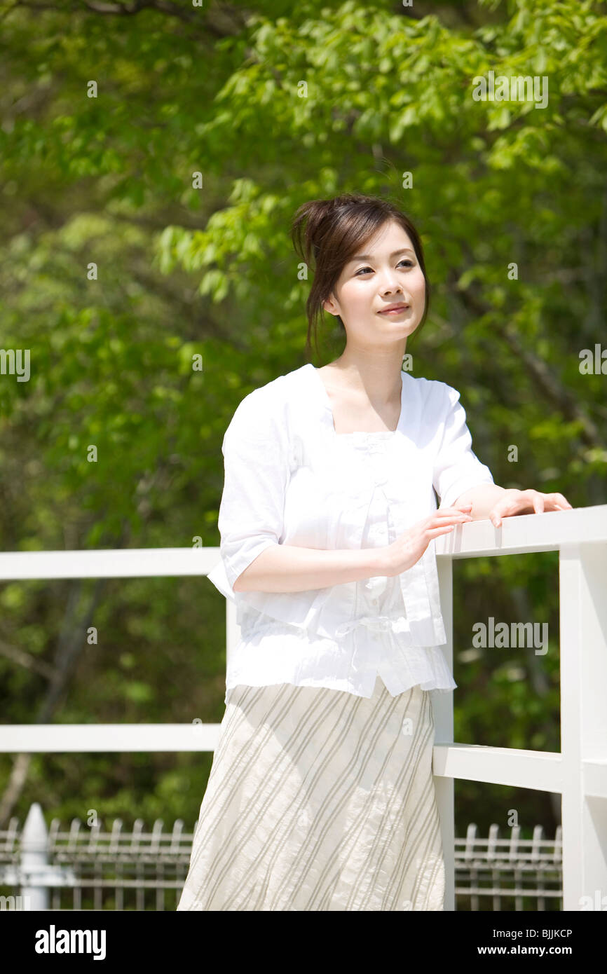 Woman leaning against a railing Stock Photo - Alamy