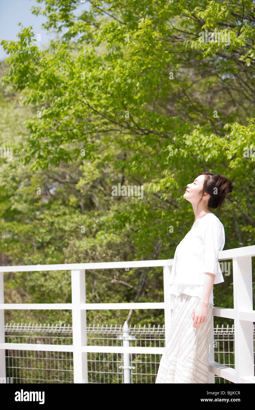 Woman leaning against a railing Stock Photo - Alamy