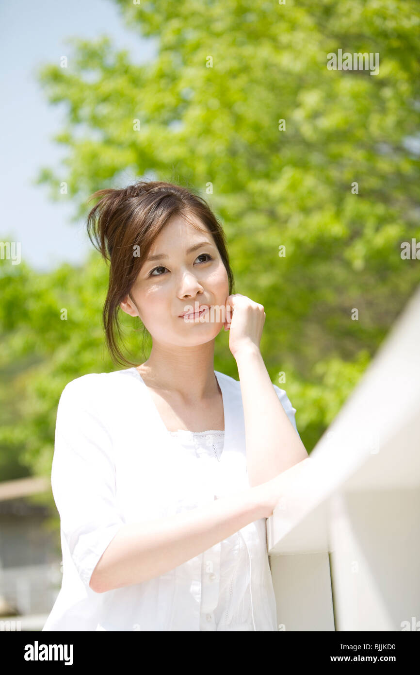 Woman leaning against a railing Stock Photo - Alamy