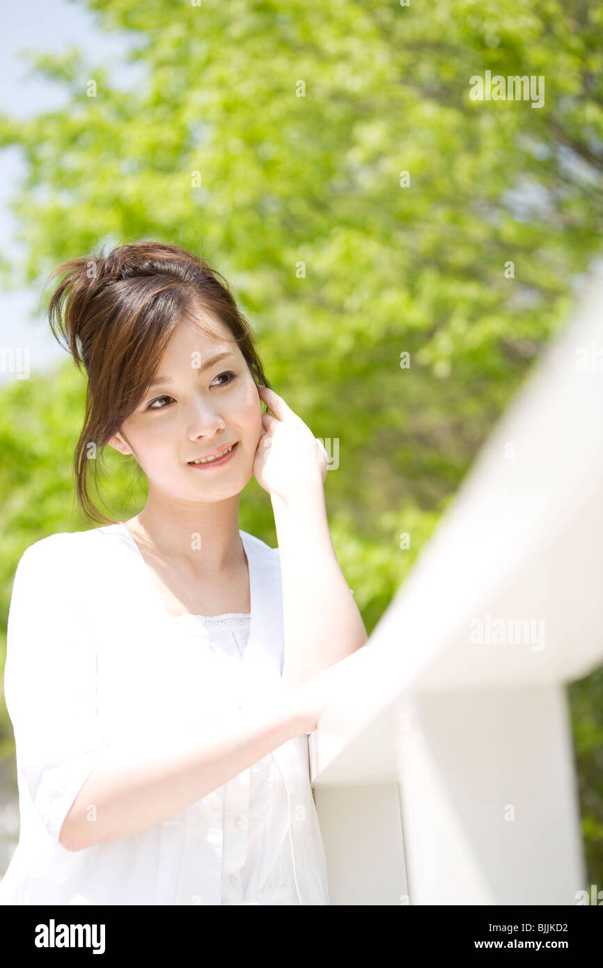 Woman leaning against a railing Stock Photo - Alamy