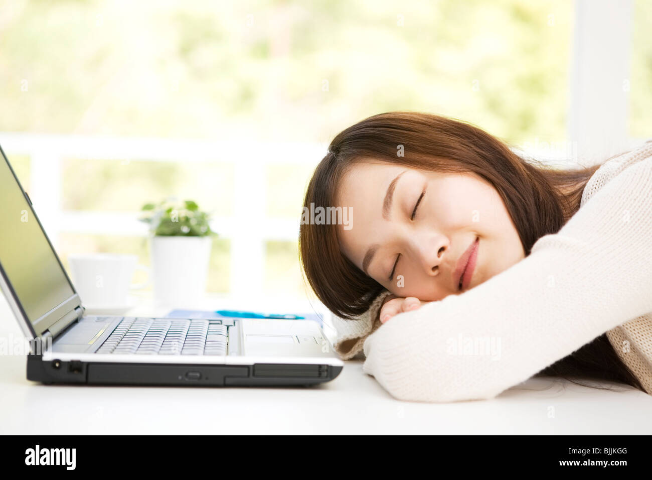 Young woman sleeping near laptop computer Stock Photo - Alamy