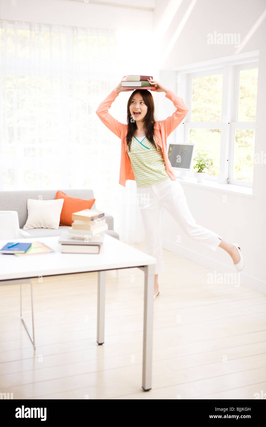 Woman balancing books on her head Stock Photo - Alamy