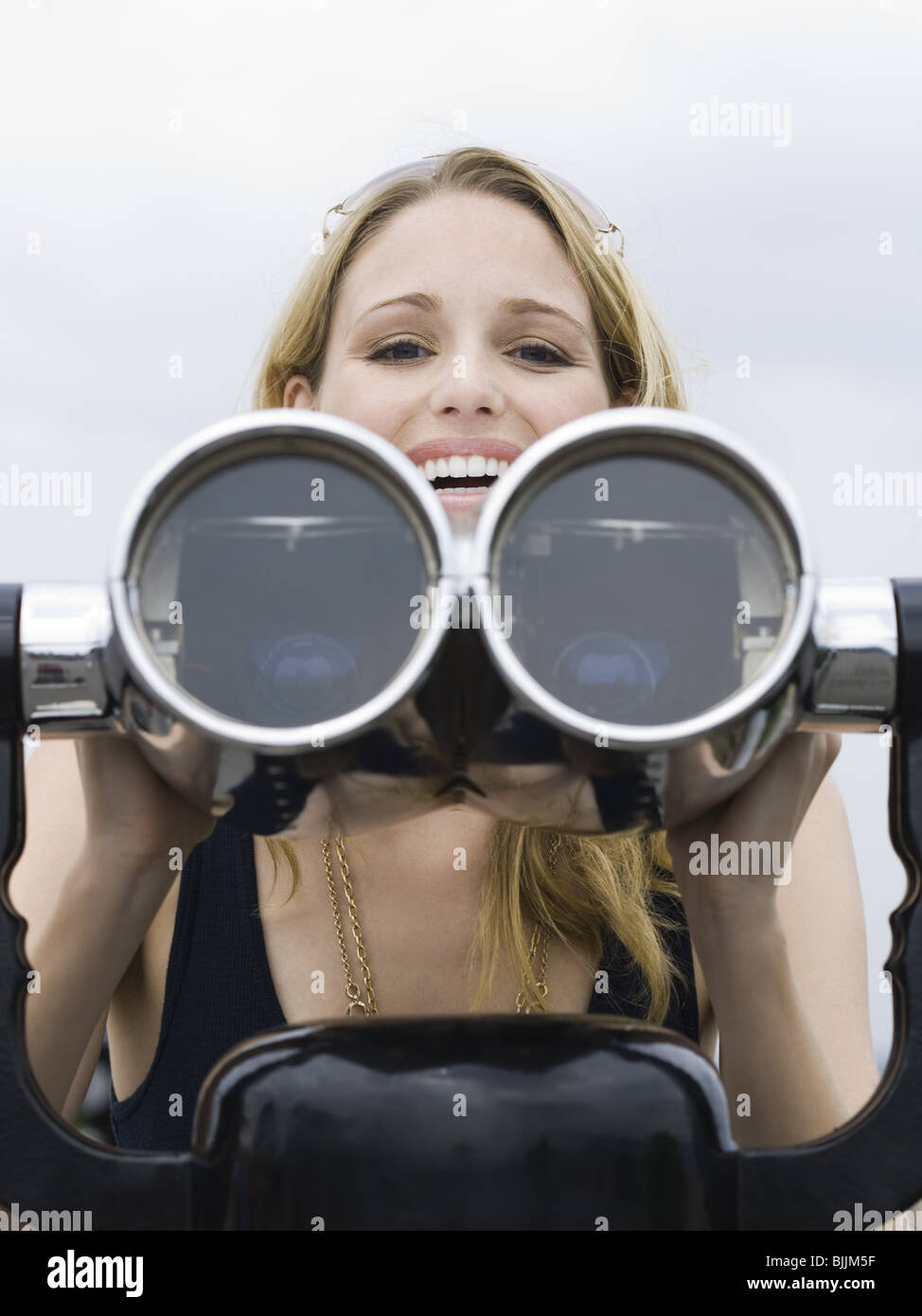 Woman with coin operated binoculars smiling Stock Photo - Alamy