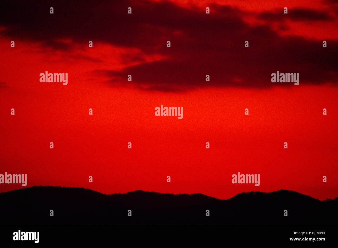 Red evening sky with silhouetted mountains Stock Photo - Alamy