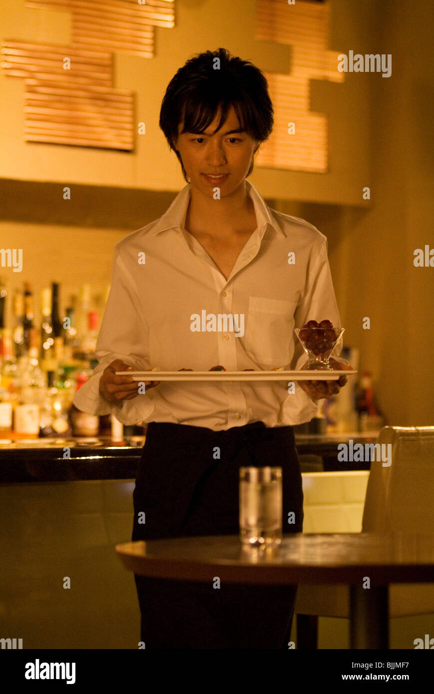 Waiter carrying a plate of food to a table Stock Photo - Alamy