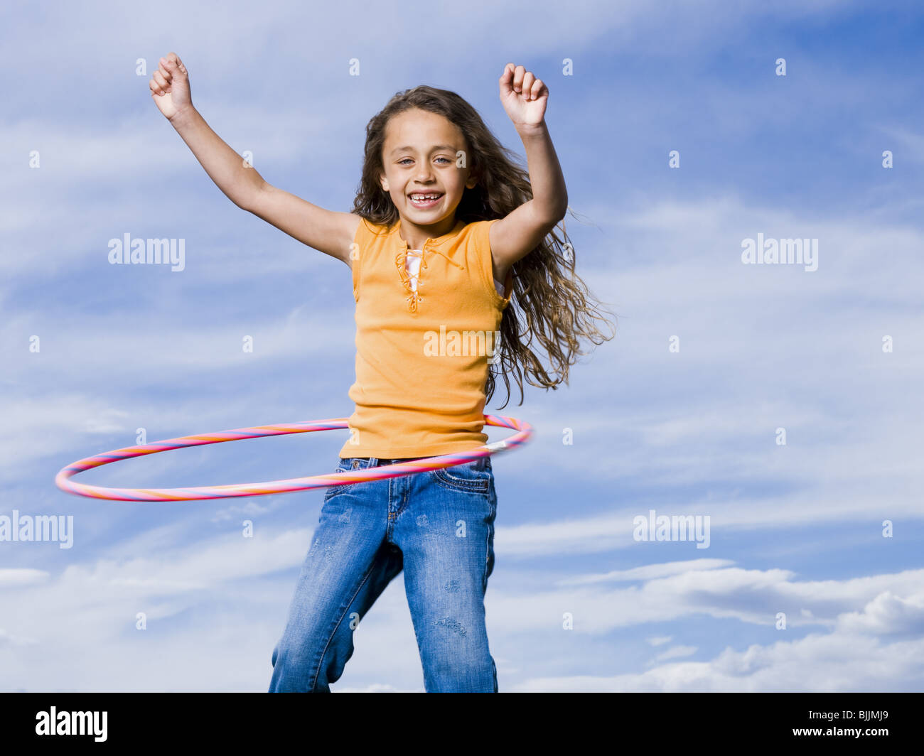 Girl playing with hula hoop outdoors laughing Stock Photo - Alamy