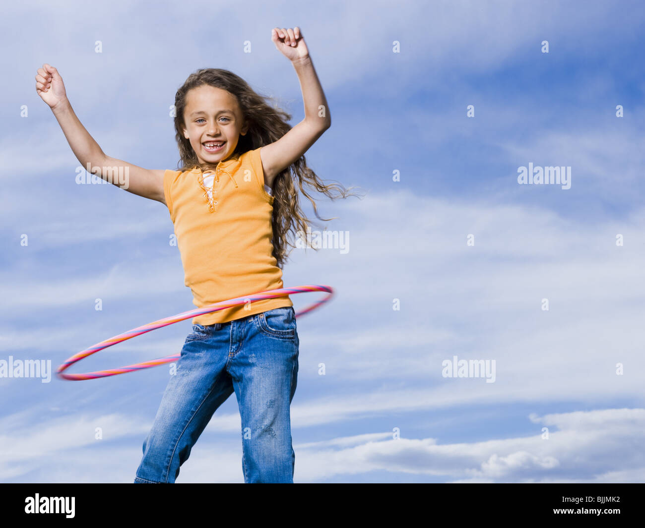 Girl playing with hula hoop outdoors laughing Stock Photo - Alamy
