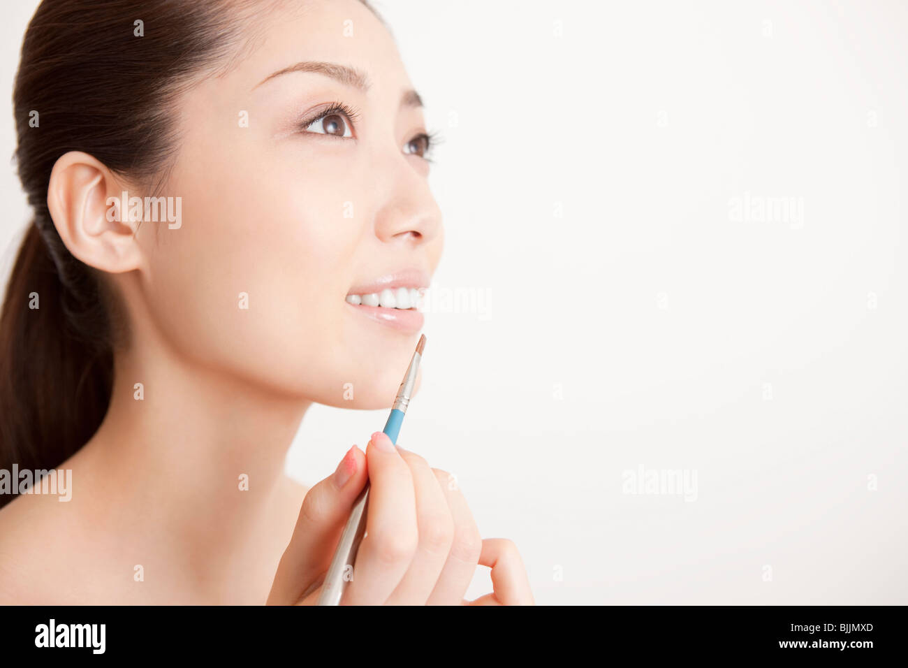 Young woman applying lipstick Stock Photo - Alamy