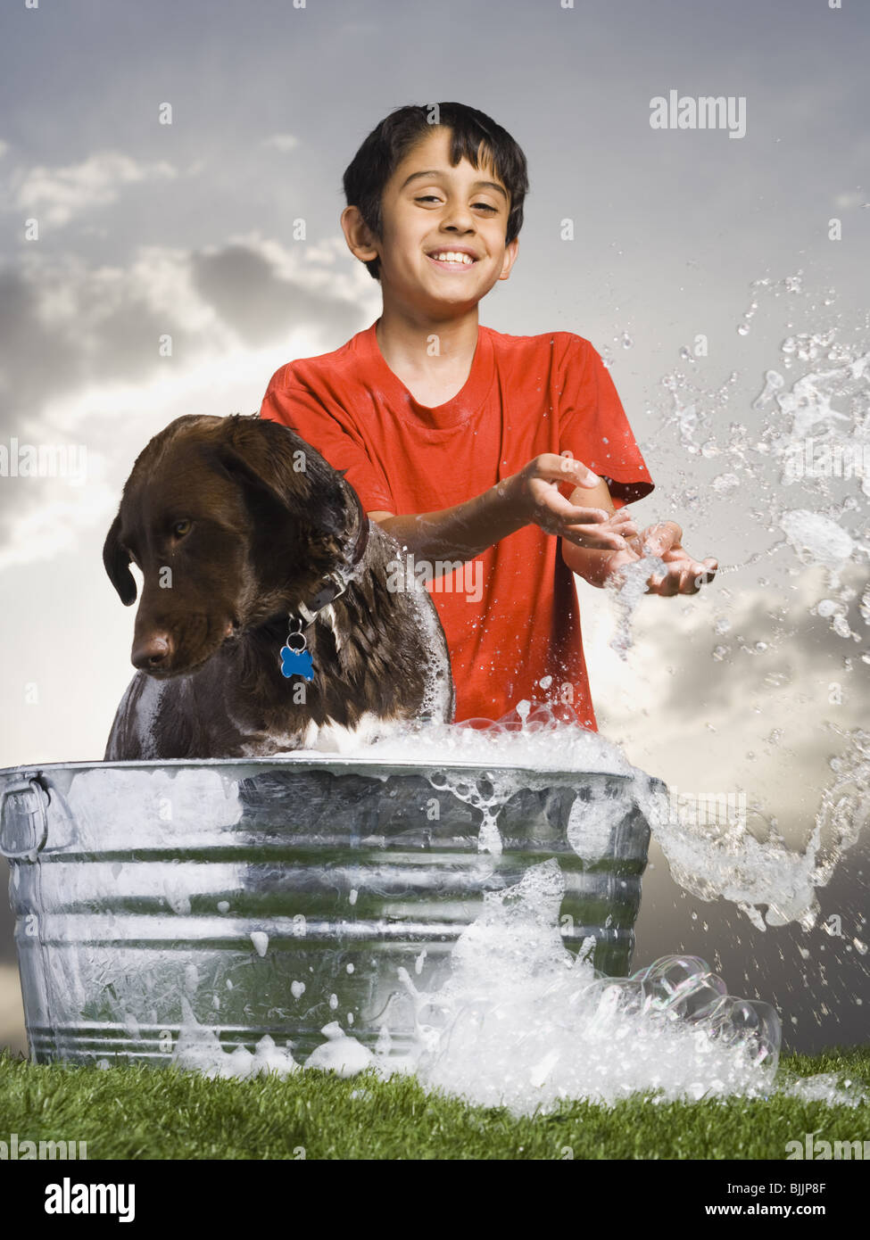 Boy bathing dog outdoors smiling Stock Photo - Alamy