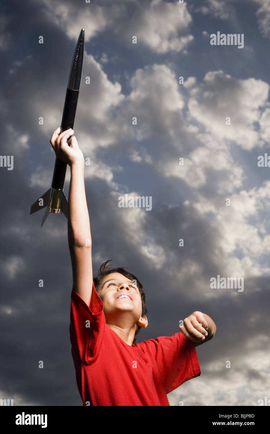 Boy playing with toy rocket outdoors on cloudy day low angle view Stock ...