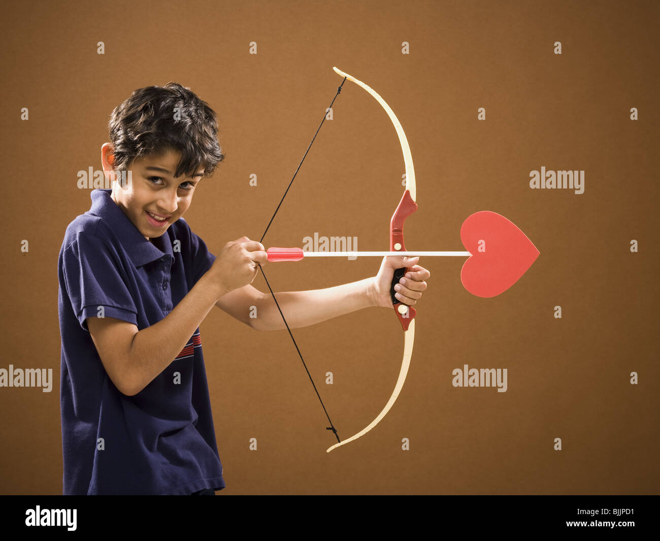 Boy with bow and arrow with heart on it Stock Photo - Alamy