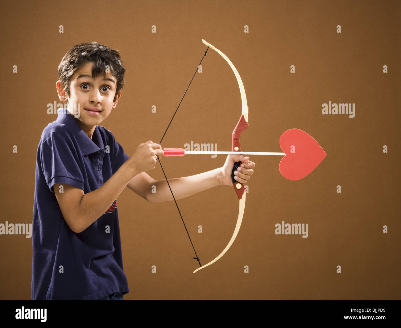 Boy with bow and arrow with heart on it Stock Photo - Alamy