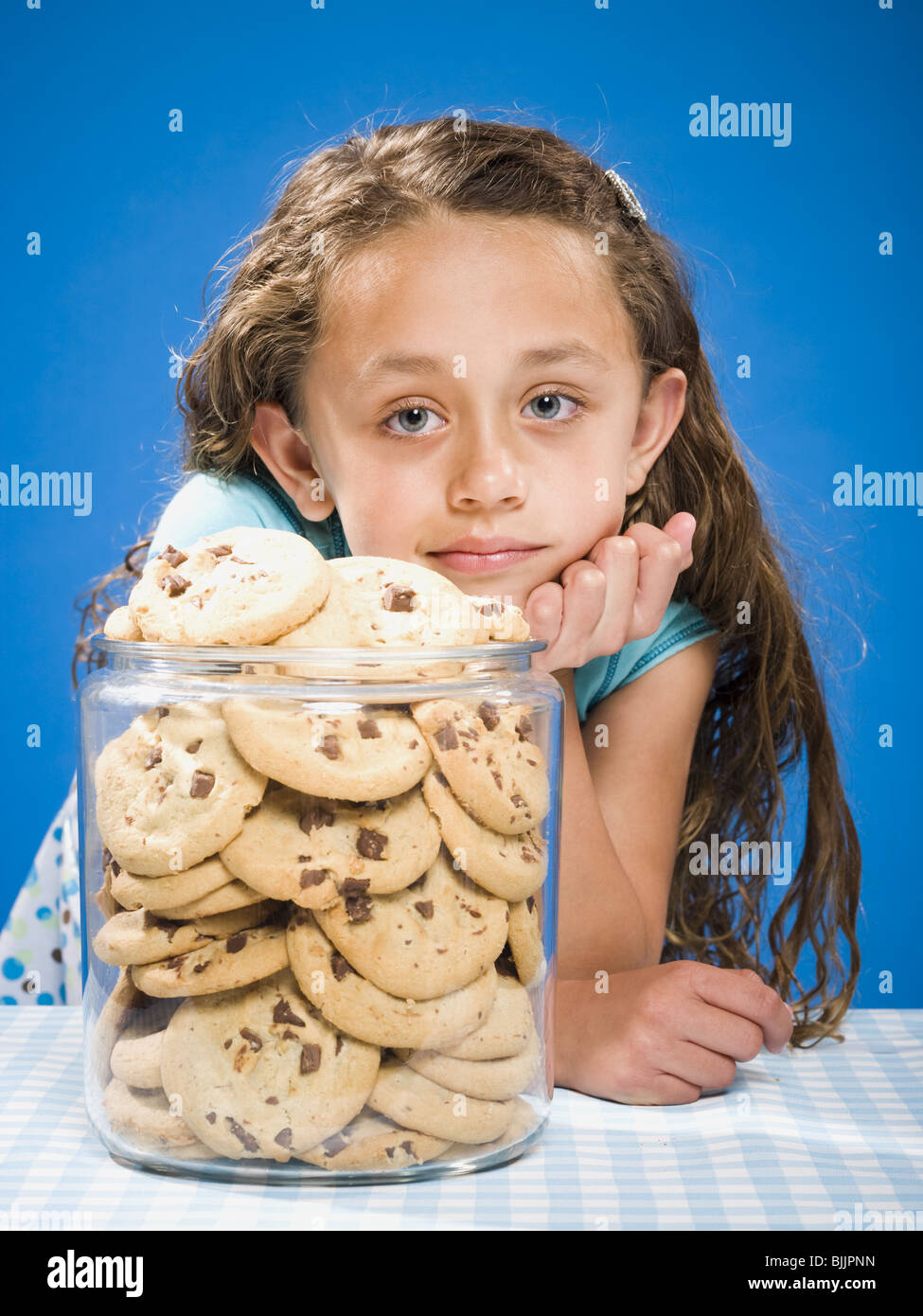 Girl looking at chocolate chip cookies in cookie jar Stock Photo - Alamy