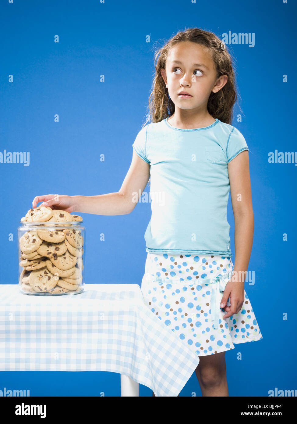 Girl sneaking Chocolate Chip Cookie from cookie jar Stock Photo - Alamy