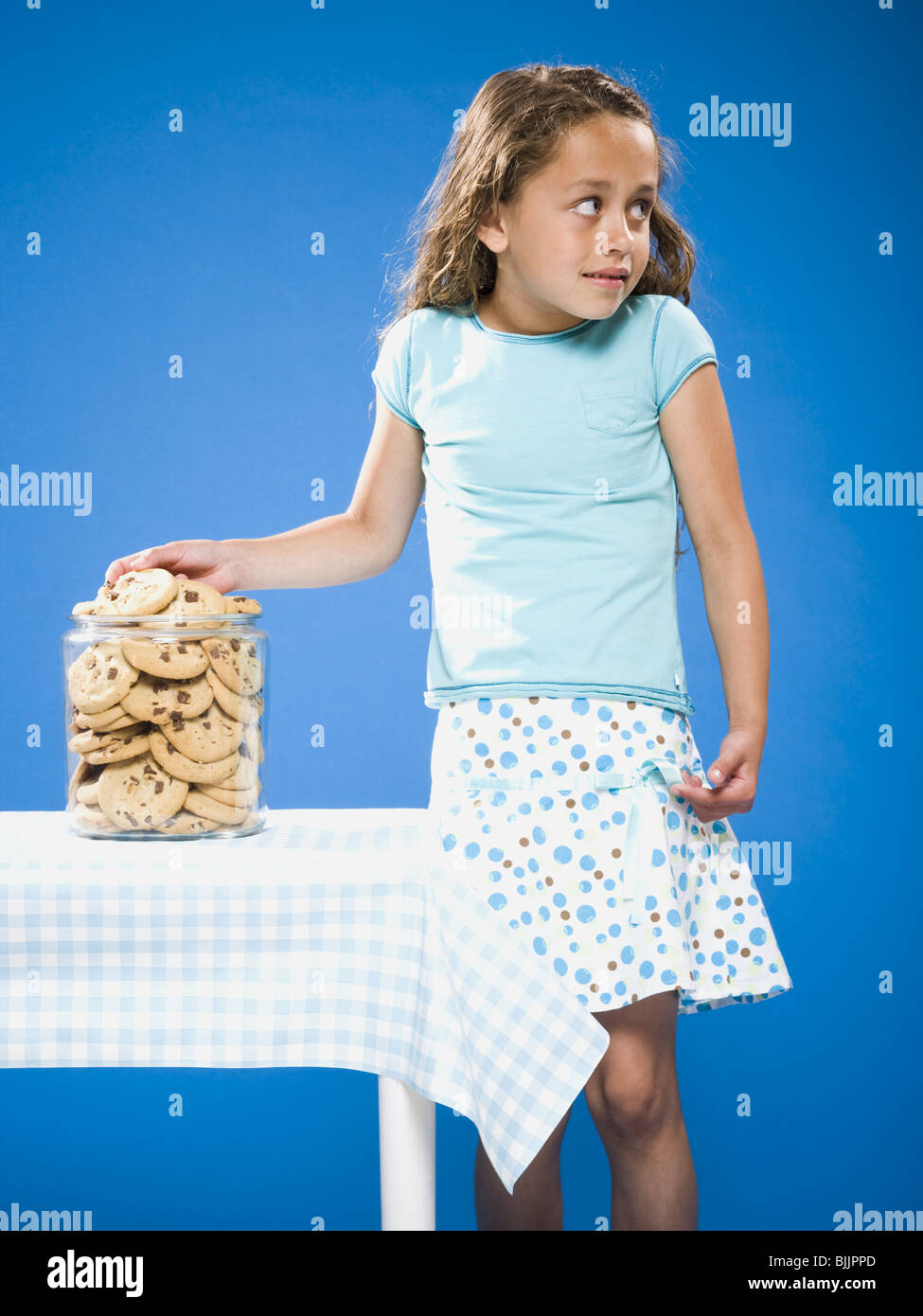 Girl sneaking Chocolate Chip Cookie from cookie jar Stock Photo - Alamy