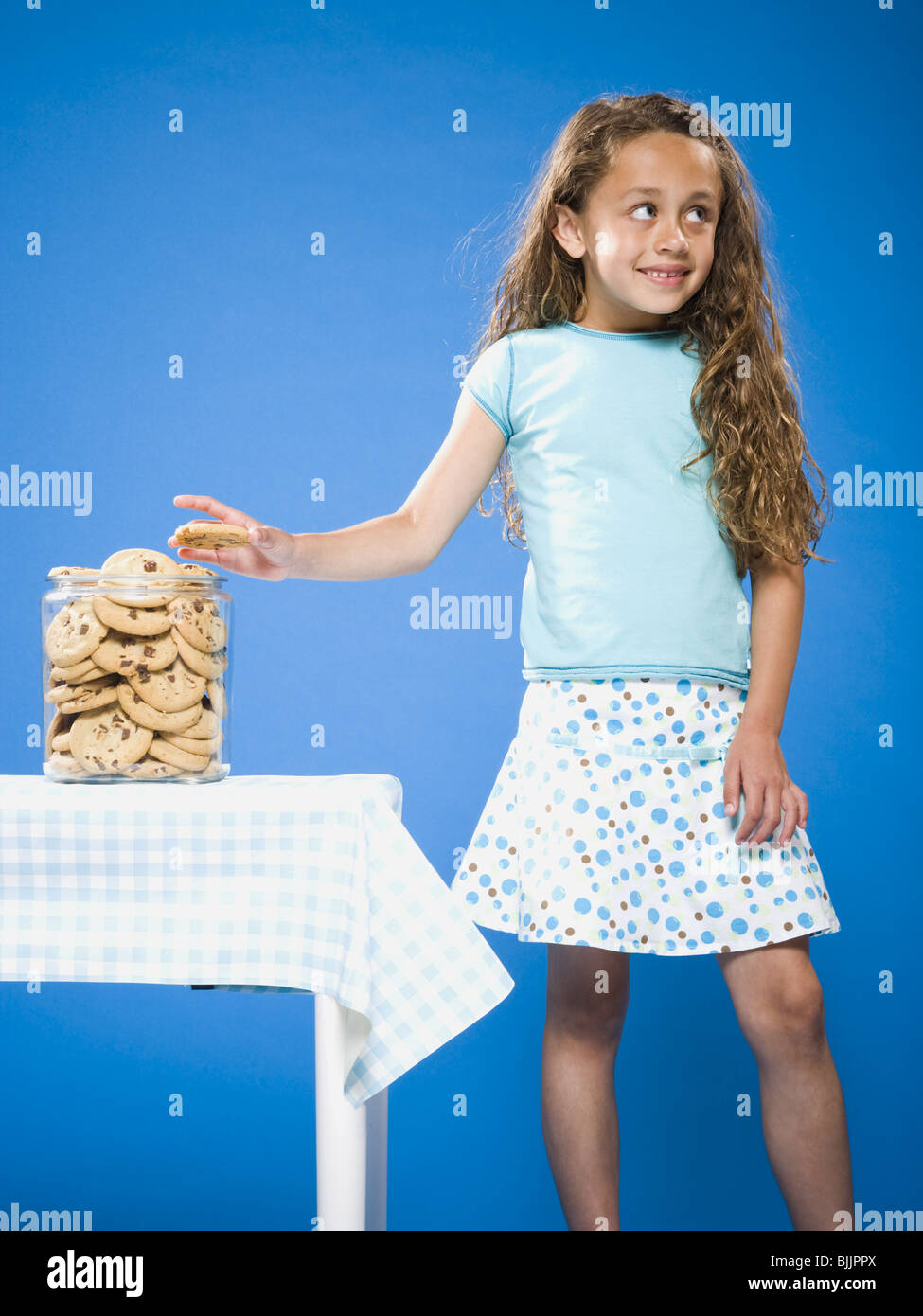 Girl sneaking Chocolate Chip Cookie from cookie jar Stock Photo - Alamy