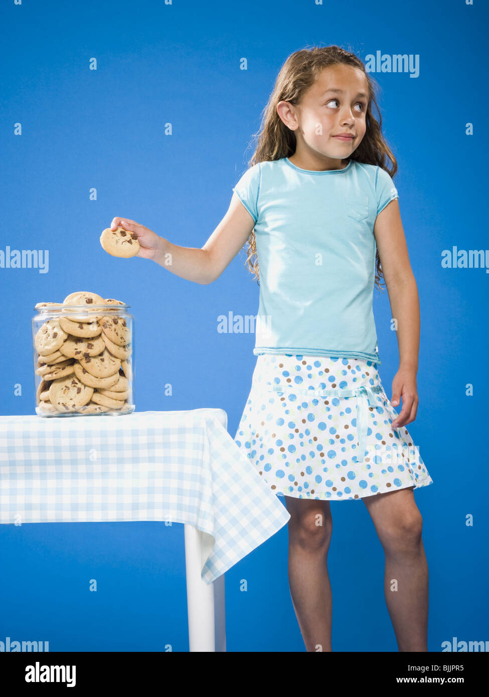 Girl sneaking Chocolate Chip Cookie from cookie jar Stock Photo - Alamy