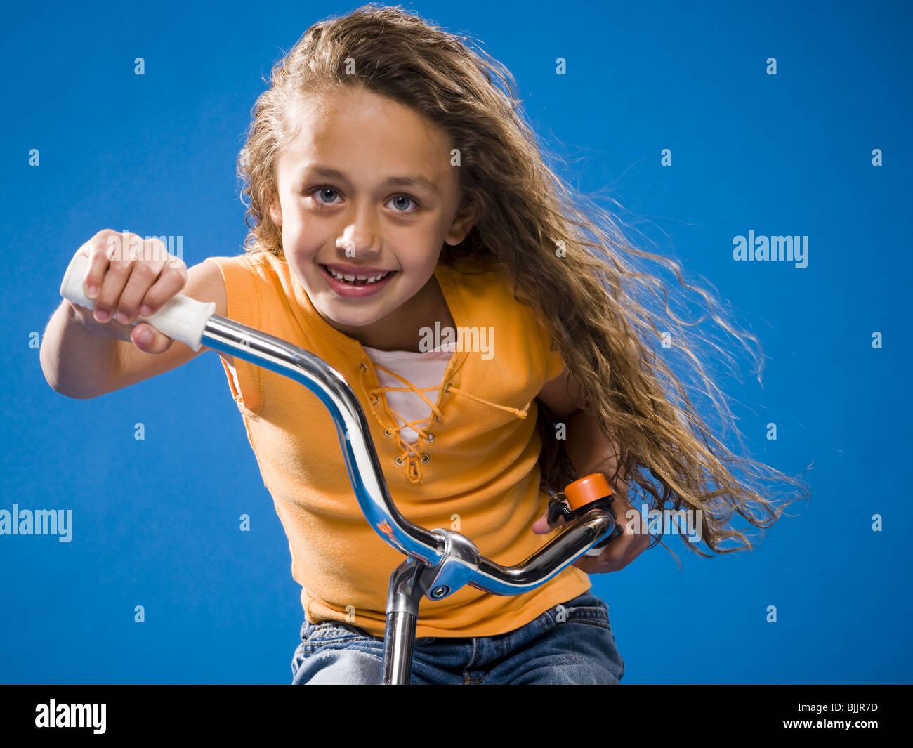 Girl riding bicycle and smiling Stock Photo - Alamy
