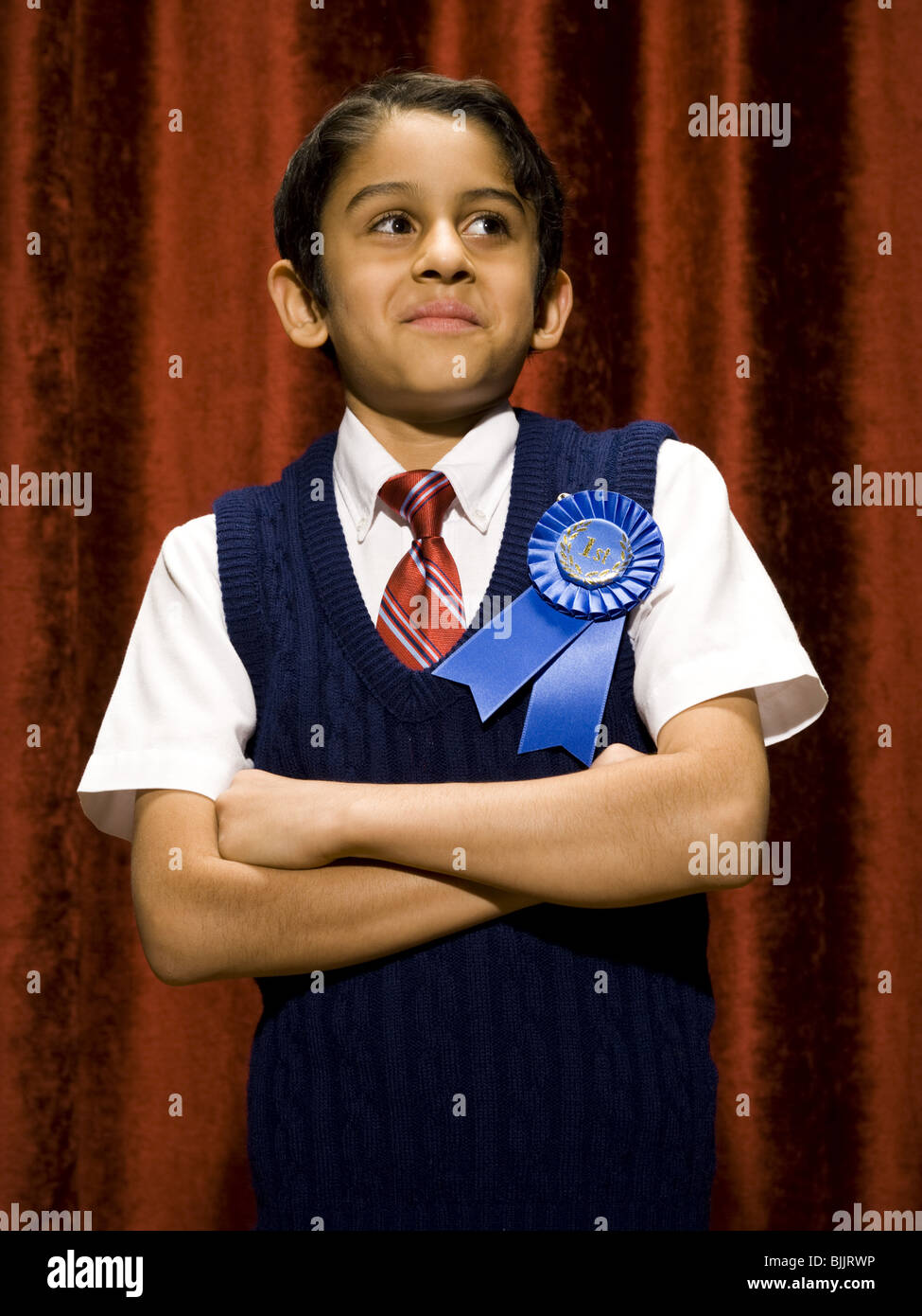 Boy with blue ribbon smiling with arms crossed Stock Photo - Alamy