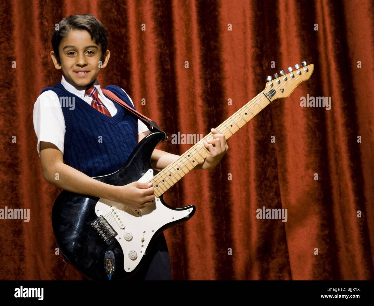 Boy on stage playing electric guitar Stock Photo - Alamy