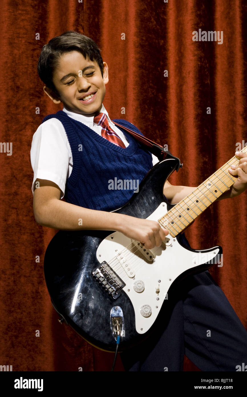Boy on stage playing electric guitar Stock Photo - Alamy