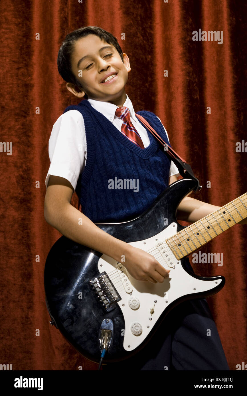 Boy on stage playing electric guitar Stock Photo - Alamy