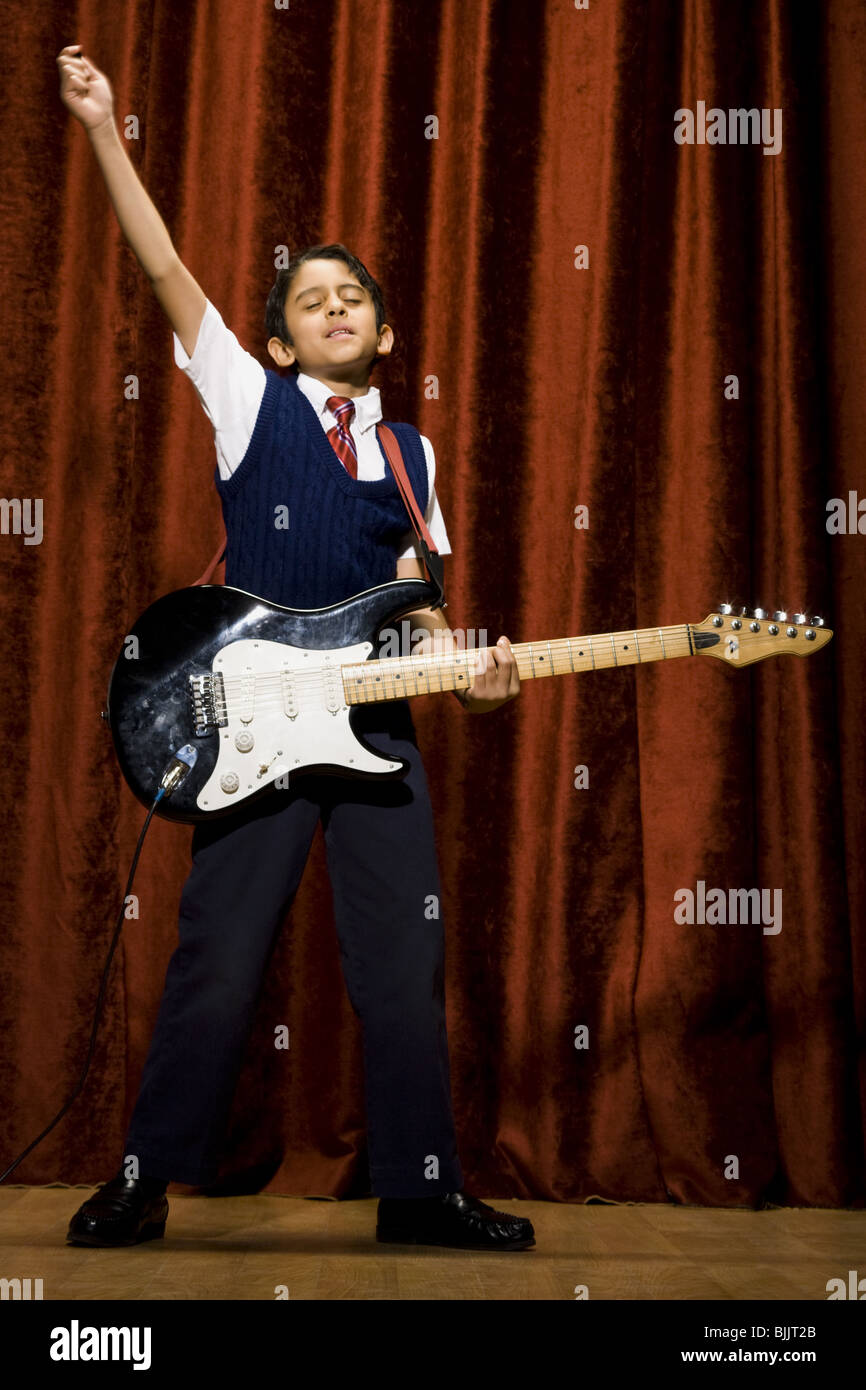 Boy on stage playing electric guitar Stock Photo - Alamy