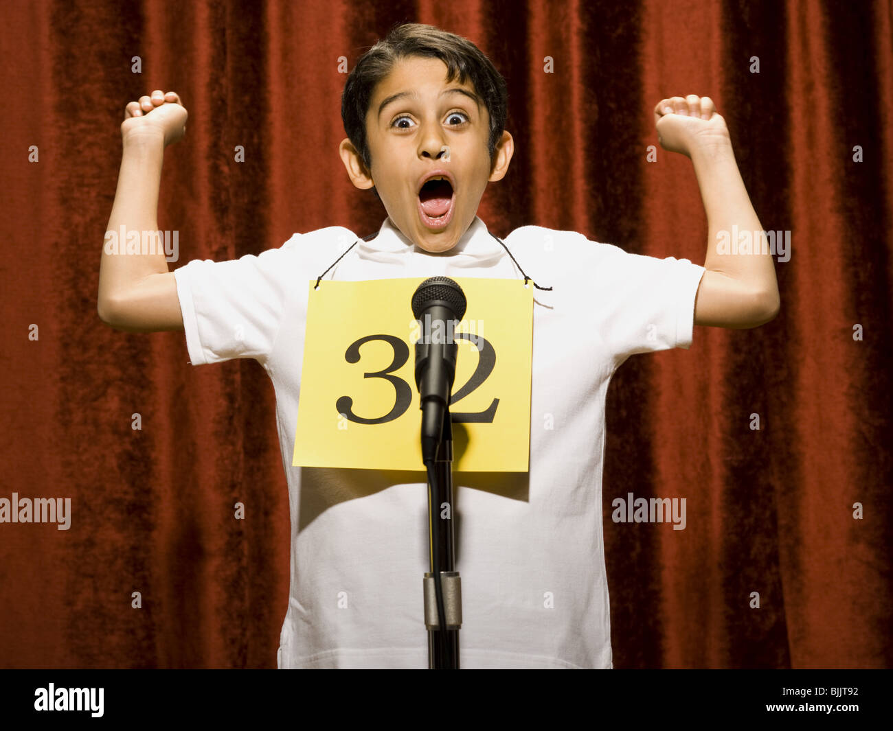 Boy contestant standing at microphone cheering Stock Photo - Alamy