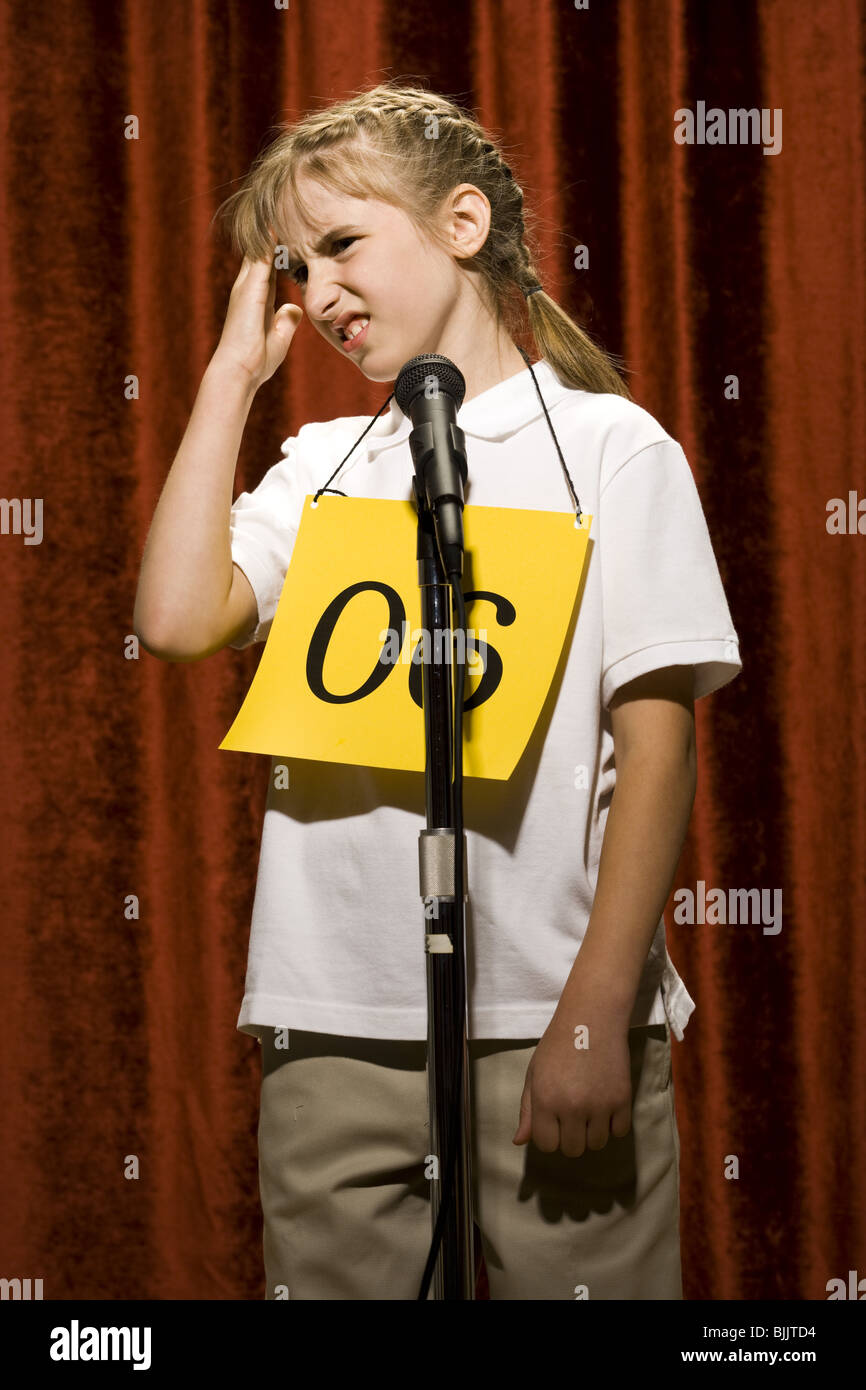 Girl contestant standing at microphone thinking Stock Photo - Alamy