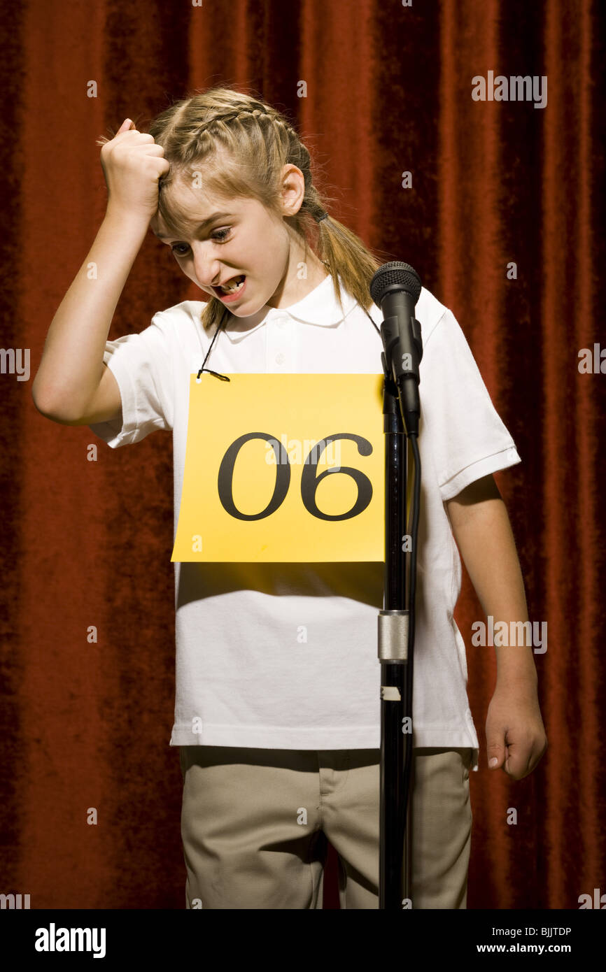 Girl contestant standing at microphone thinking Stock Photo - Alamy