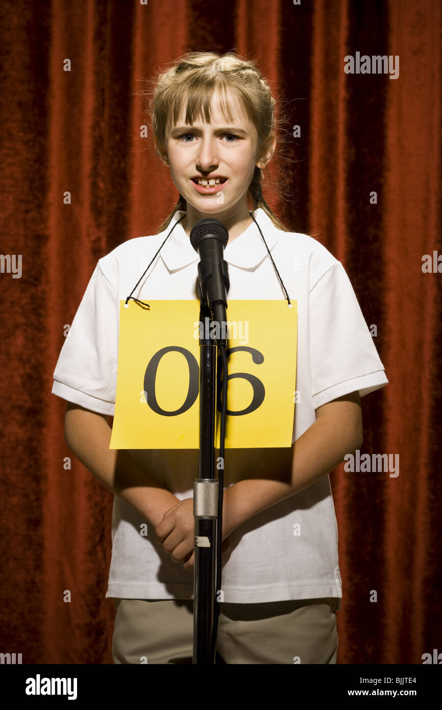 Girl contestant standing at microphone thinking Stock Photo - Alamy