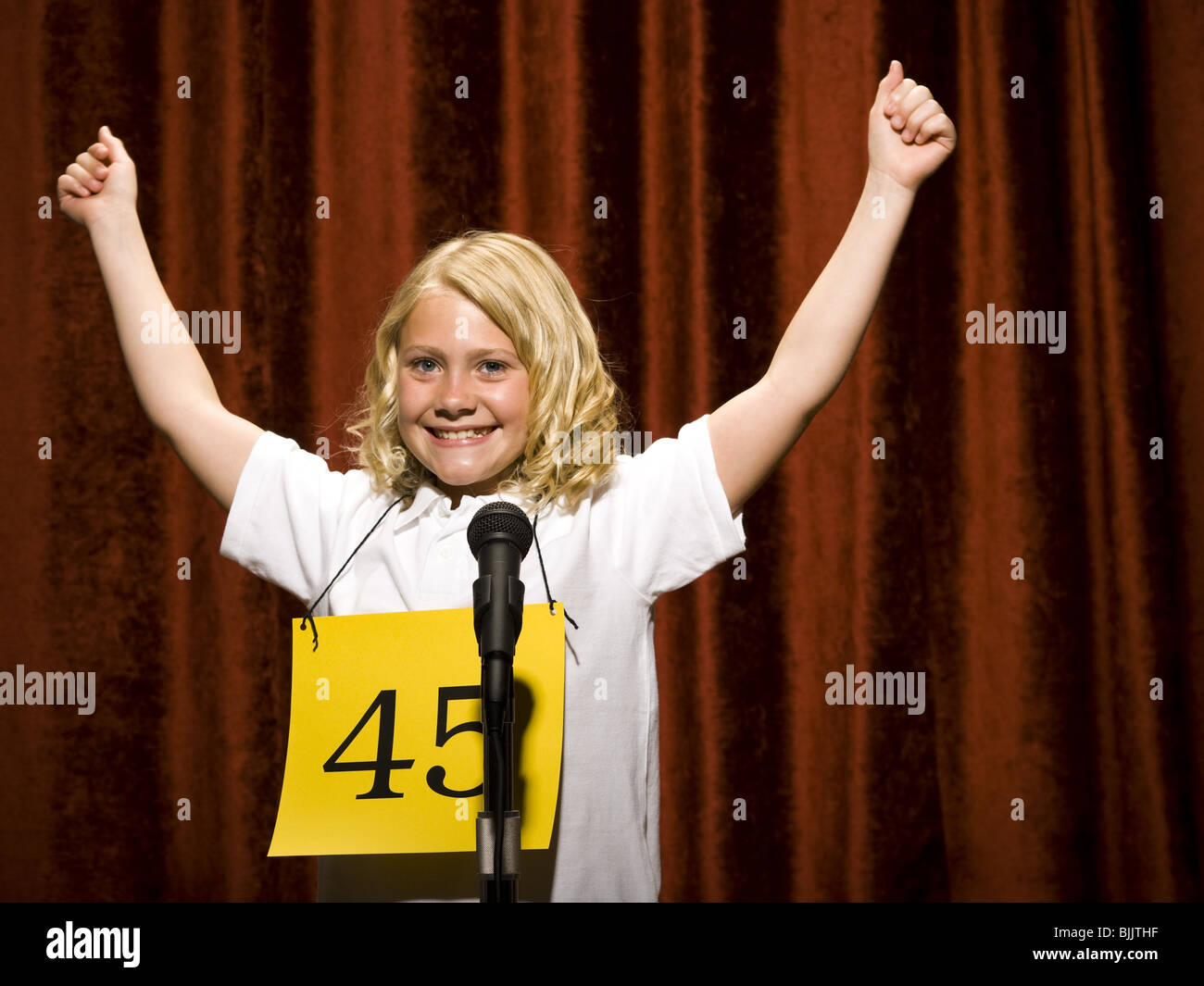 Girl contestant standing at microphone cheering Stock Photo - Alamy