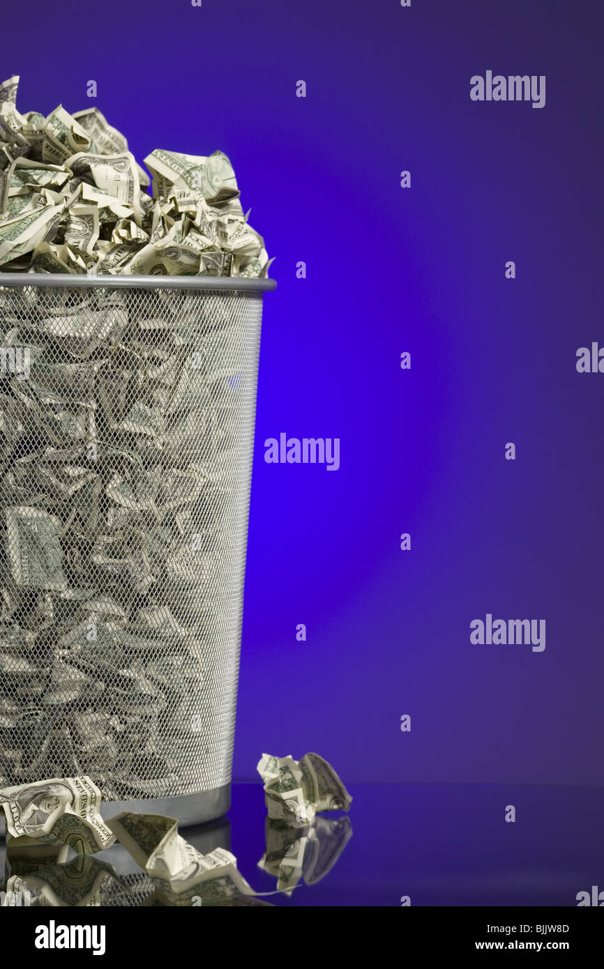 Crumpled money in waste paper basket Stock Photo - Alamy