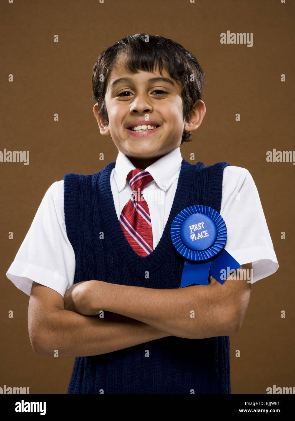 Boy with first place ribbon and arms crossed smiling Stock Photo - Alamy