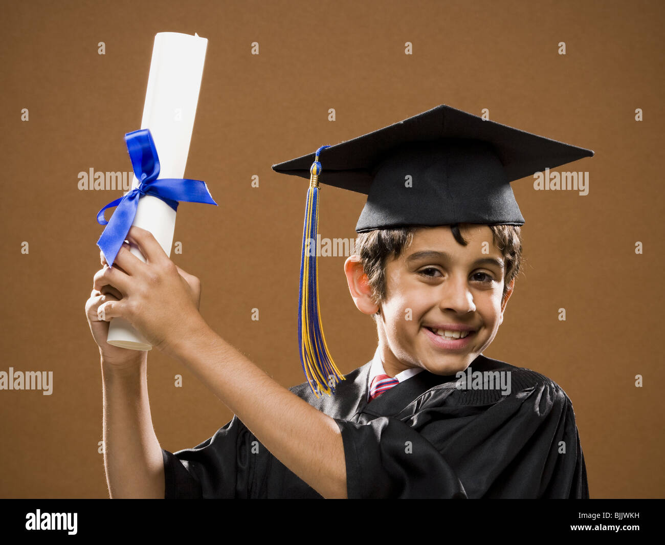 Boy graduate with mortar board and diploma smiling Stock Photo - Alamy