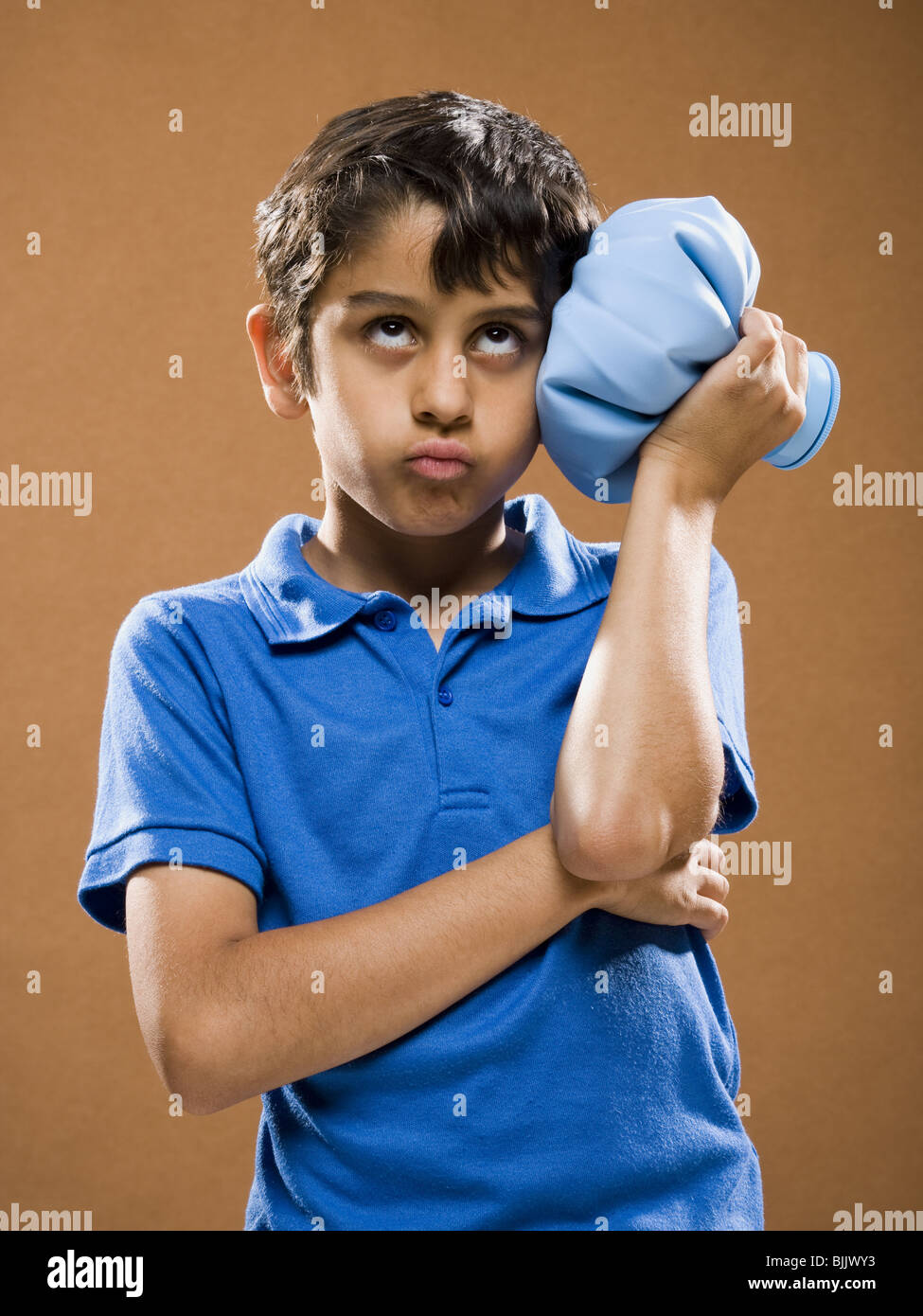 Boy holding ice pack to head Stock Photo - Alamy