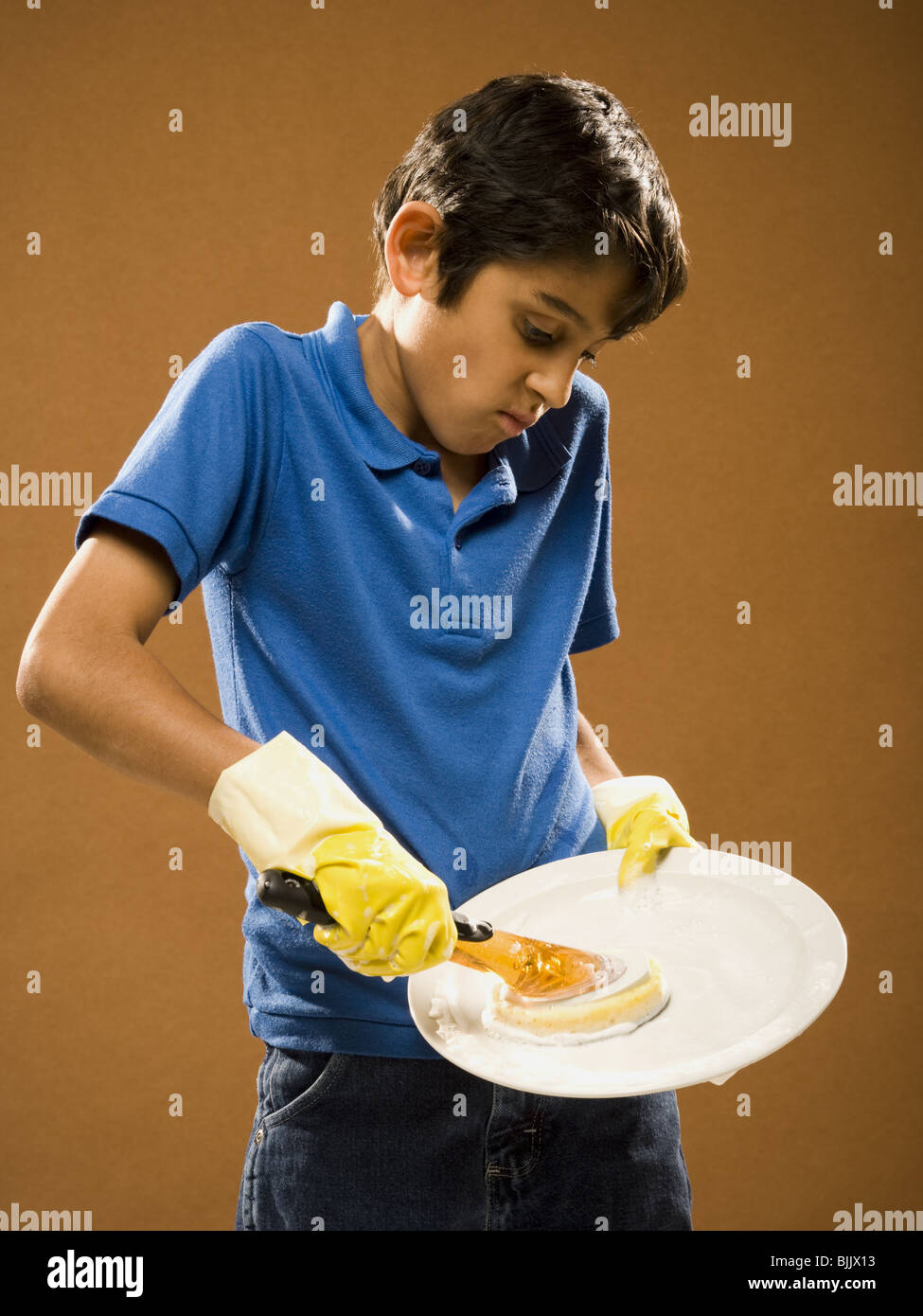 Boy with rubber gloves scrubbing plate Stock Photo - Alamy