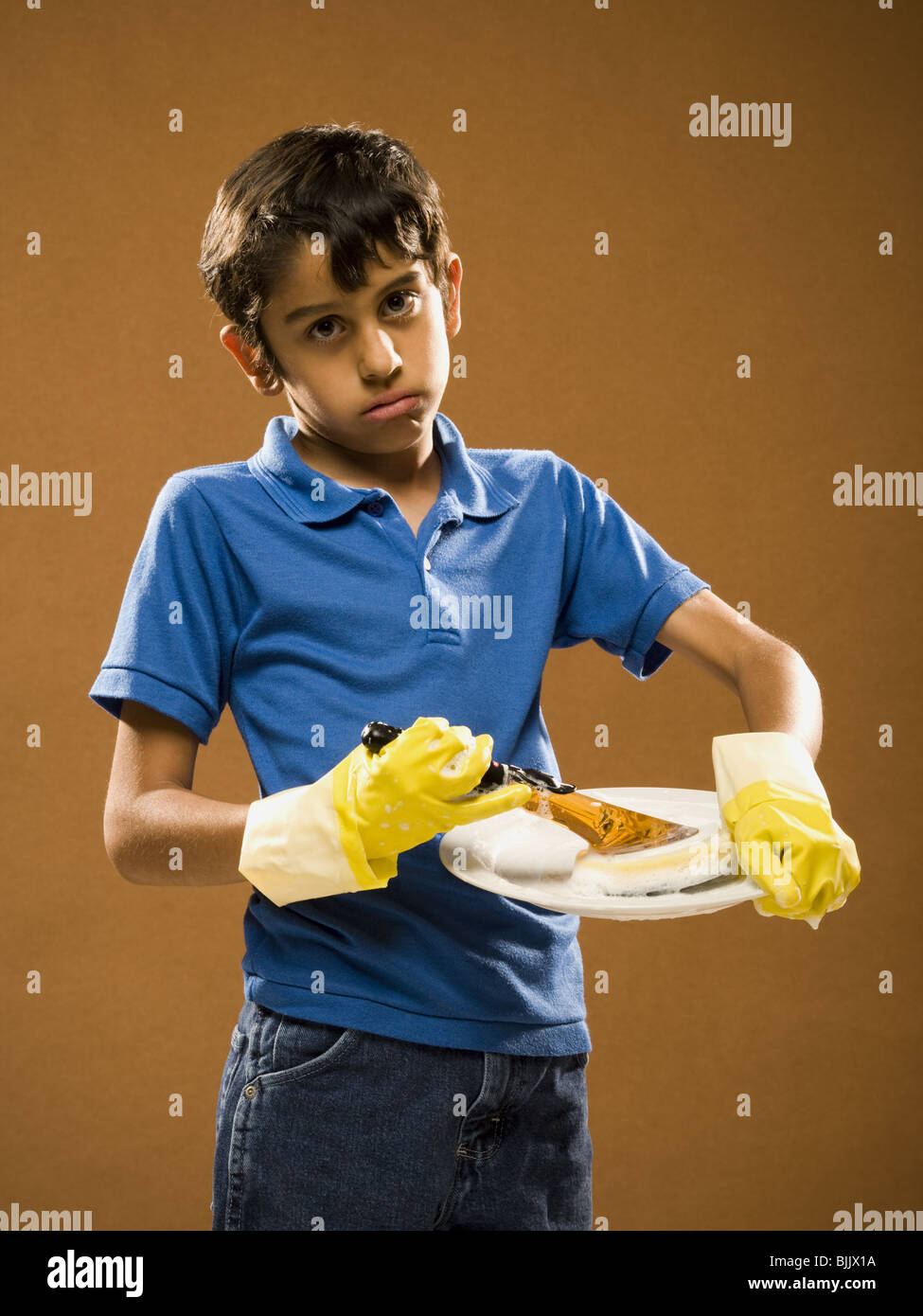 Boy with rubber gloves scrubbing plate Stock Photo - Alamy