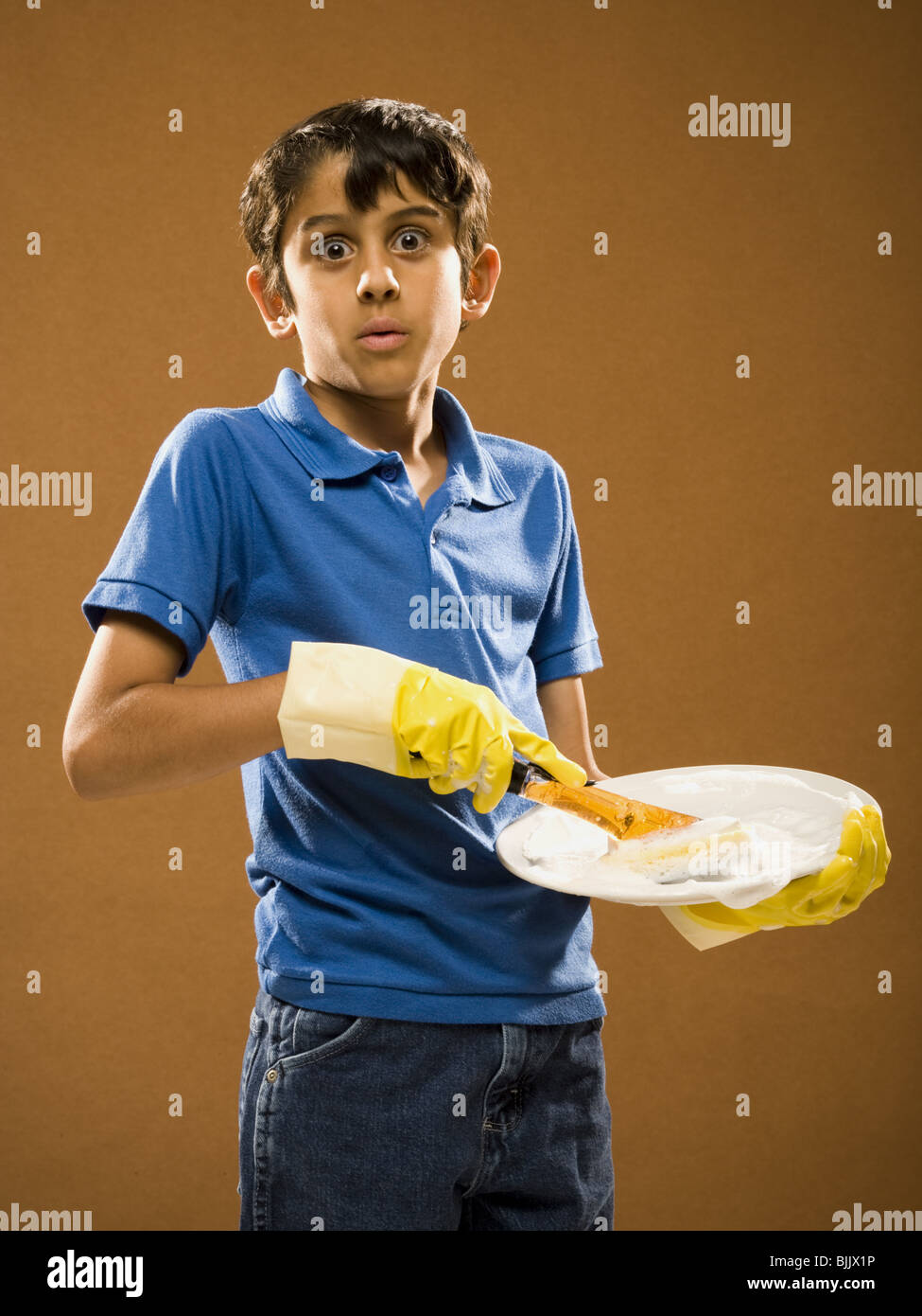 Boy with rubber gloves scrubbing plate Stock Photo - Alamy