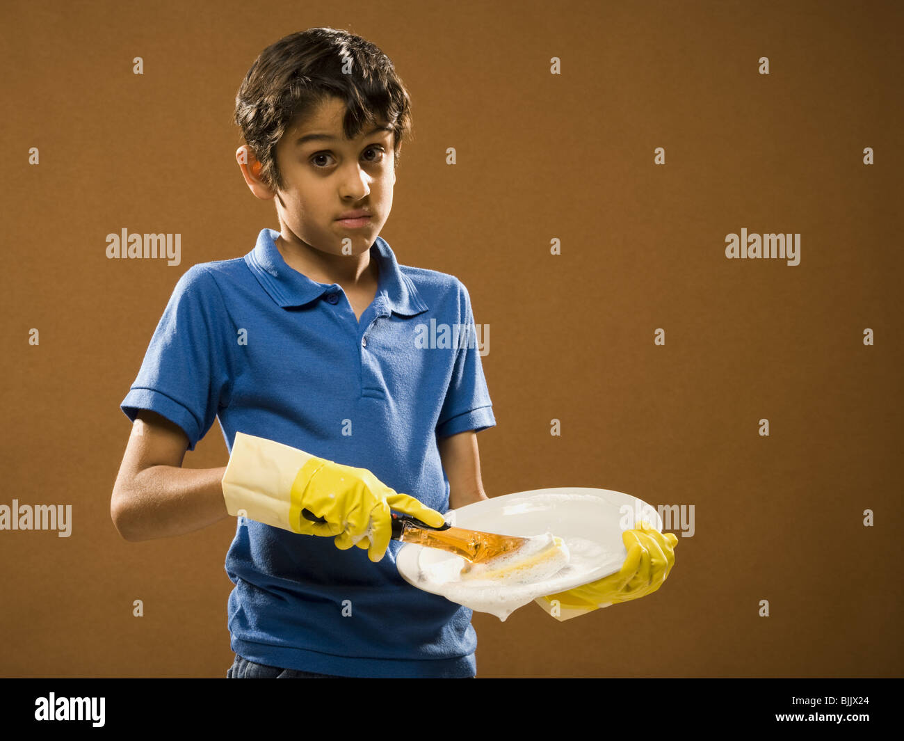 Boy with rubber gloves scrubbing plate Stock Photo - Alamy