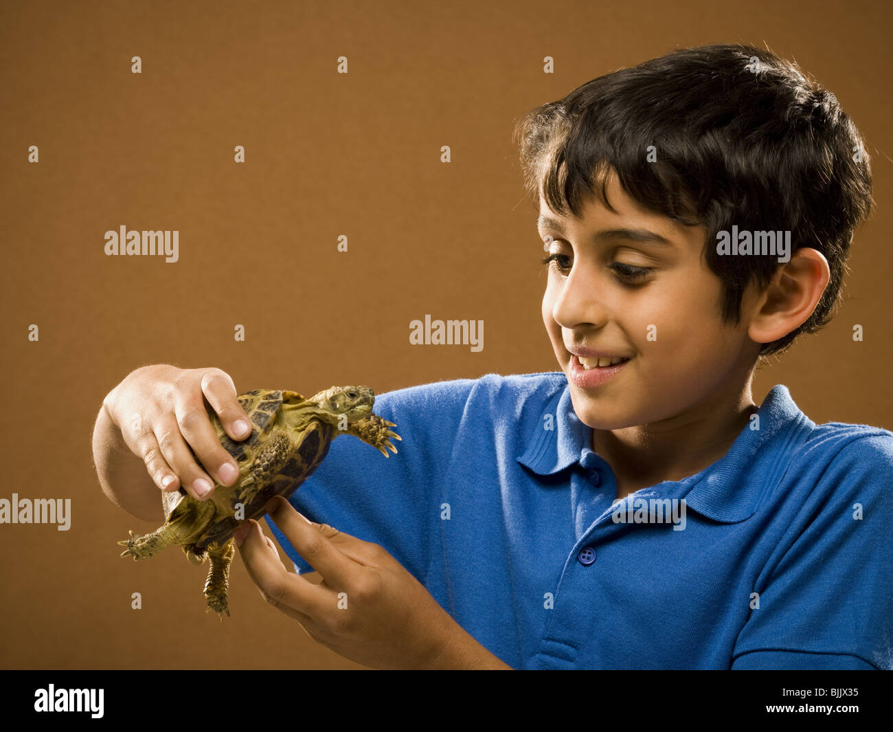 Boy holding turtle smiling Stock Photo - Alamy