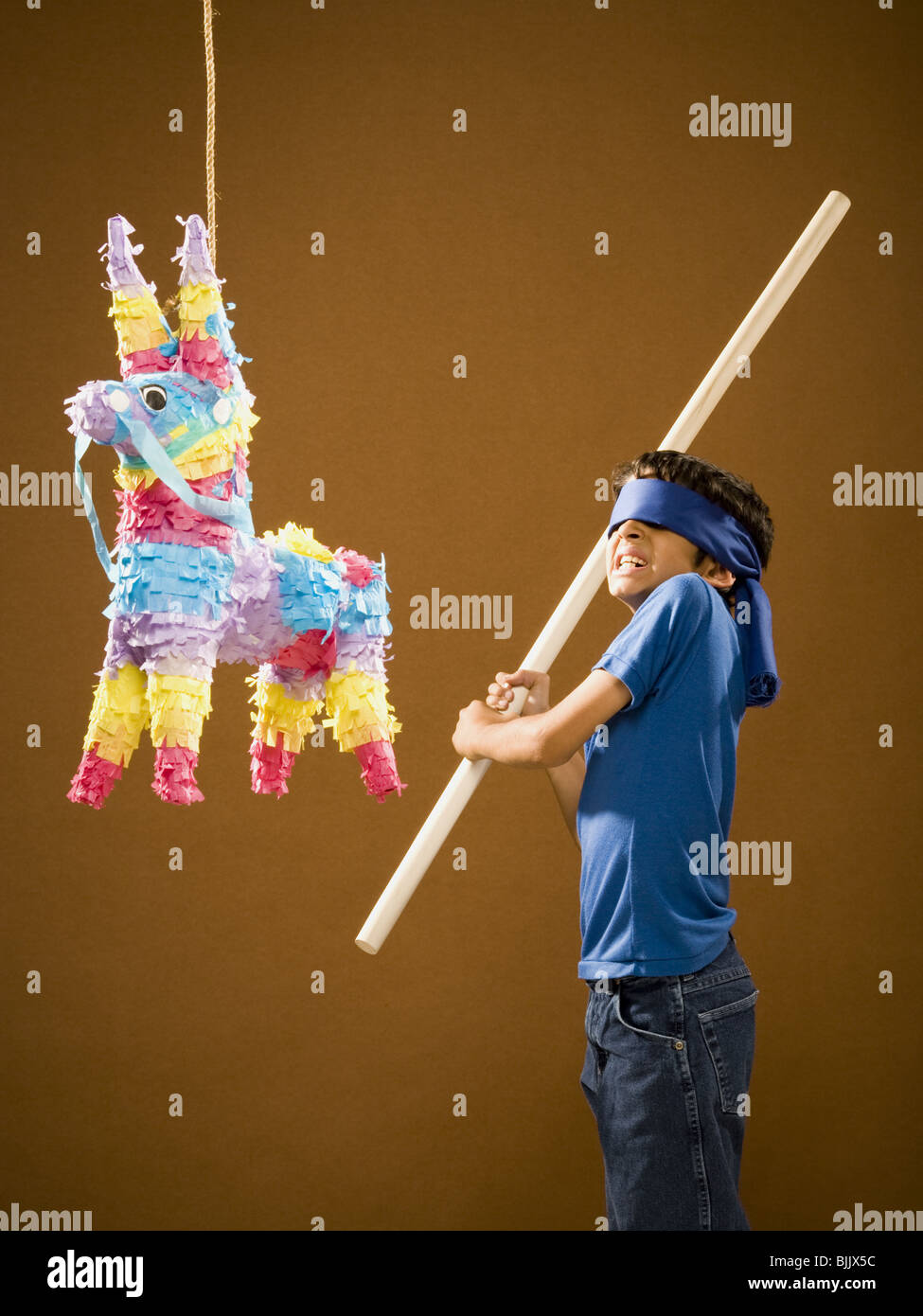 Blindfolded boy with stick and pinata Stock Photo - Alamy