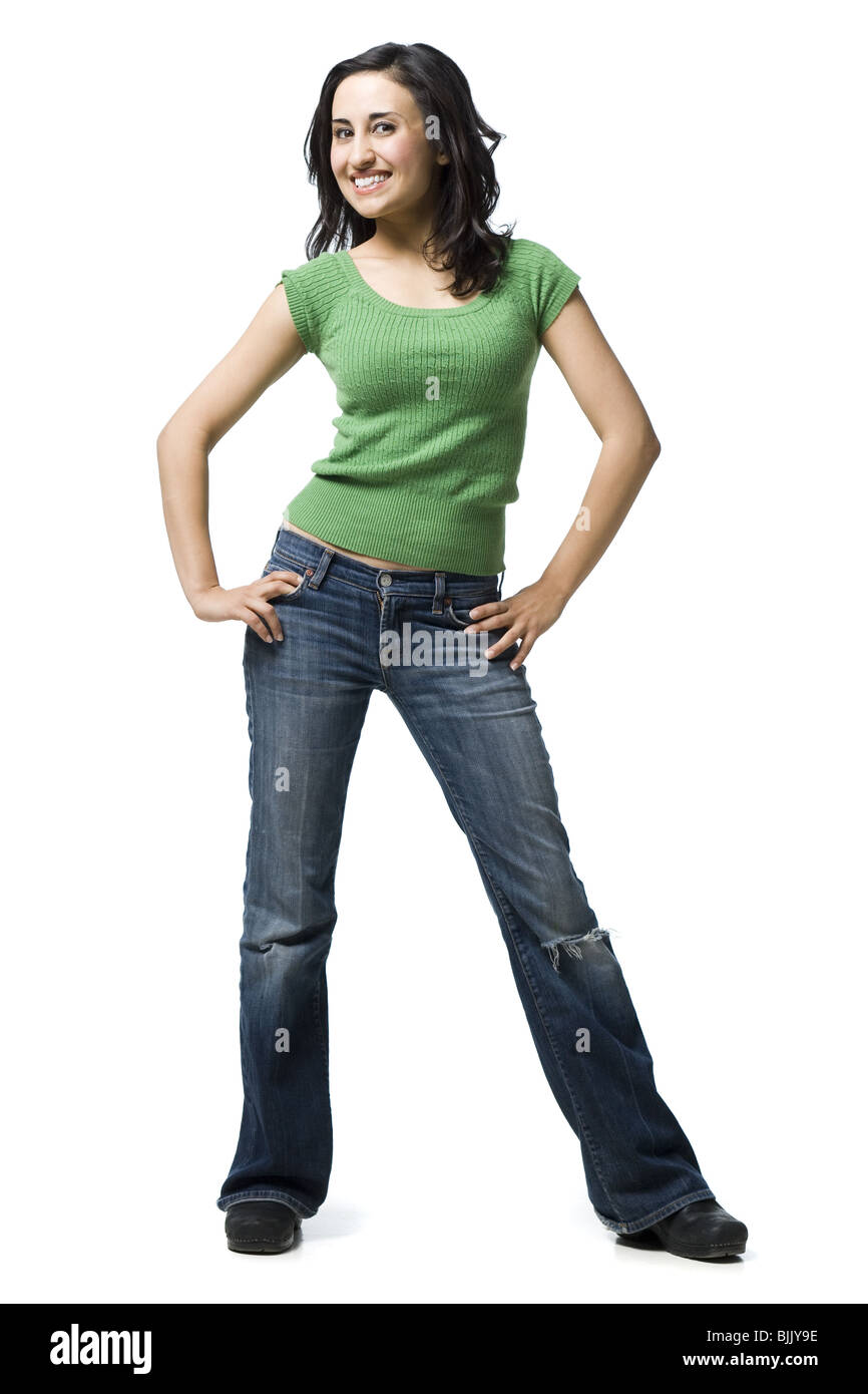 Woman standing with hands on hips smiling Stock Photo - Alamy