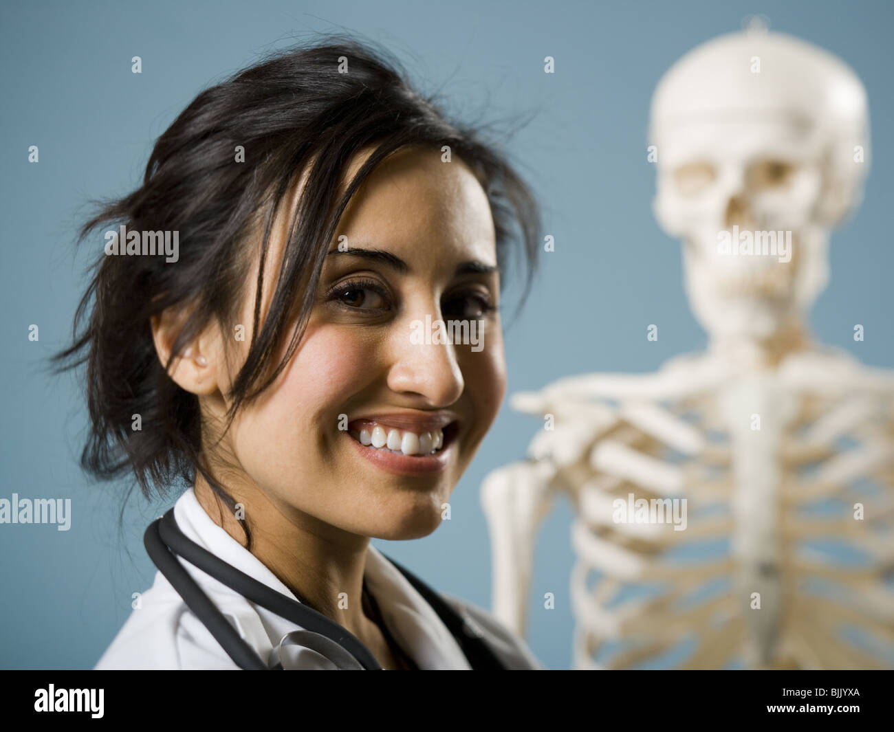 Female doctor smiling with skeleton in background Stock Photo - Alamy