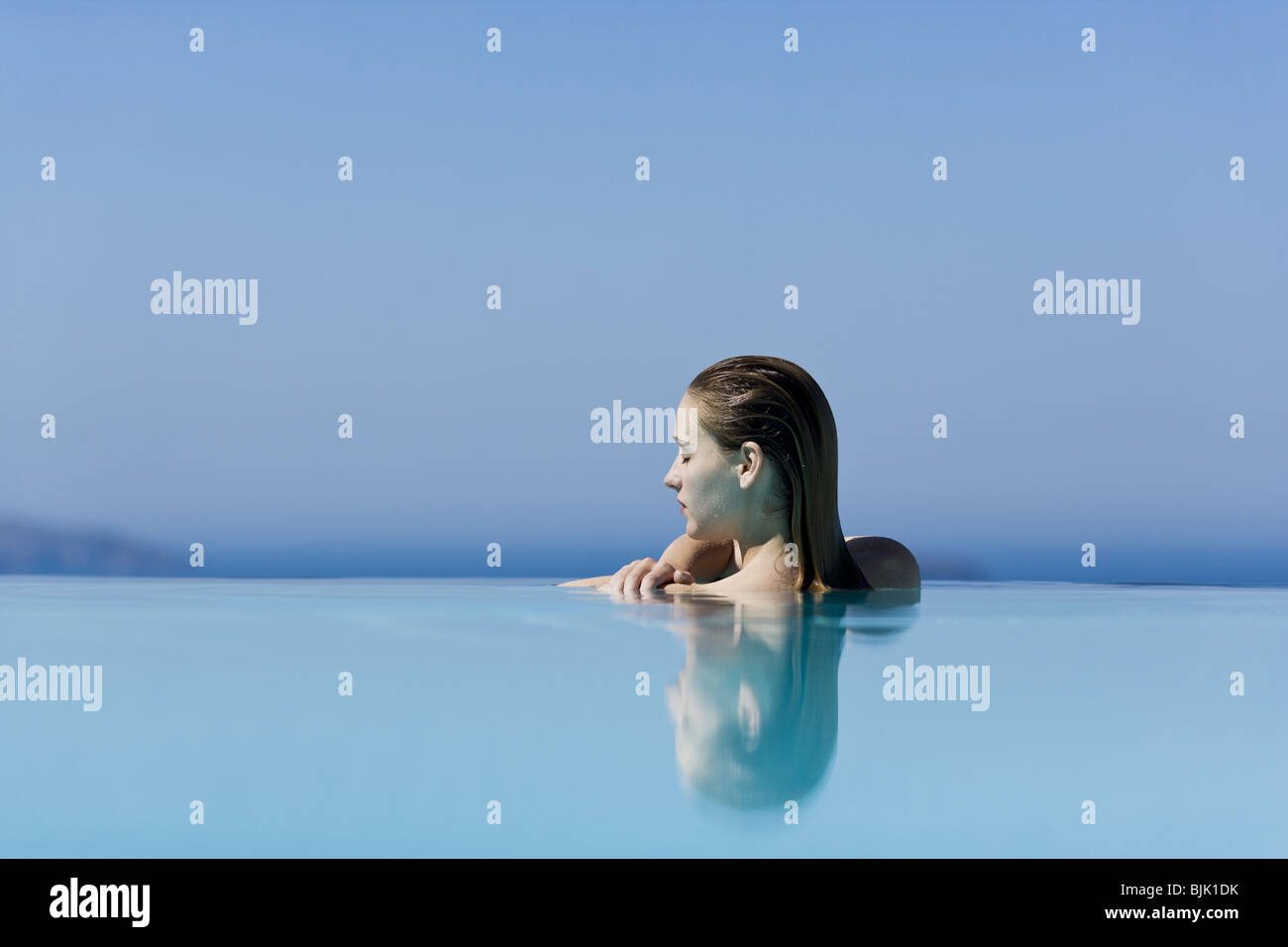 Woman in infinity pool reflection Stock Photo - Alamy