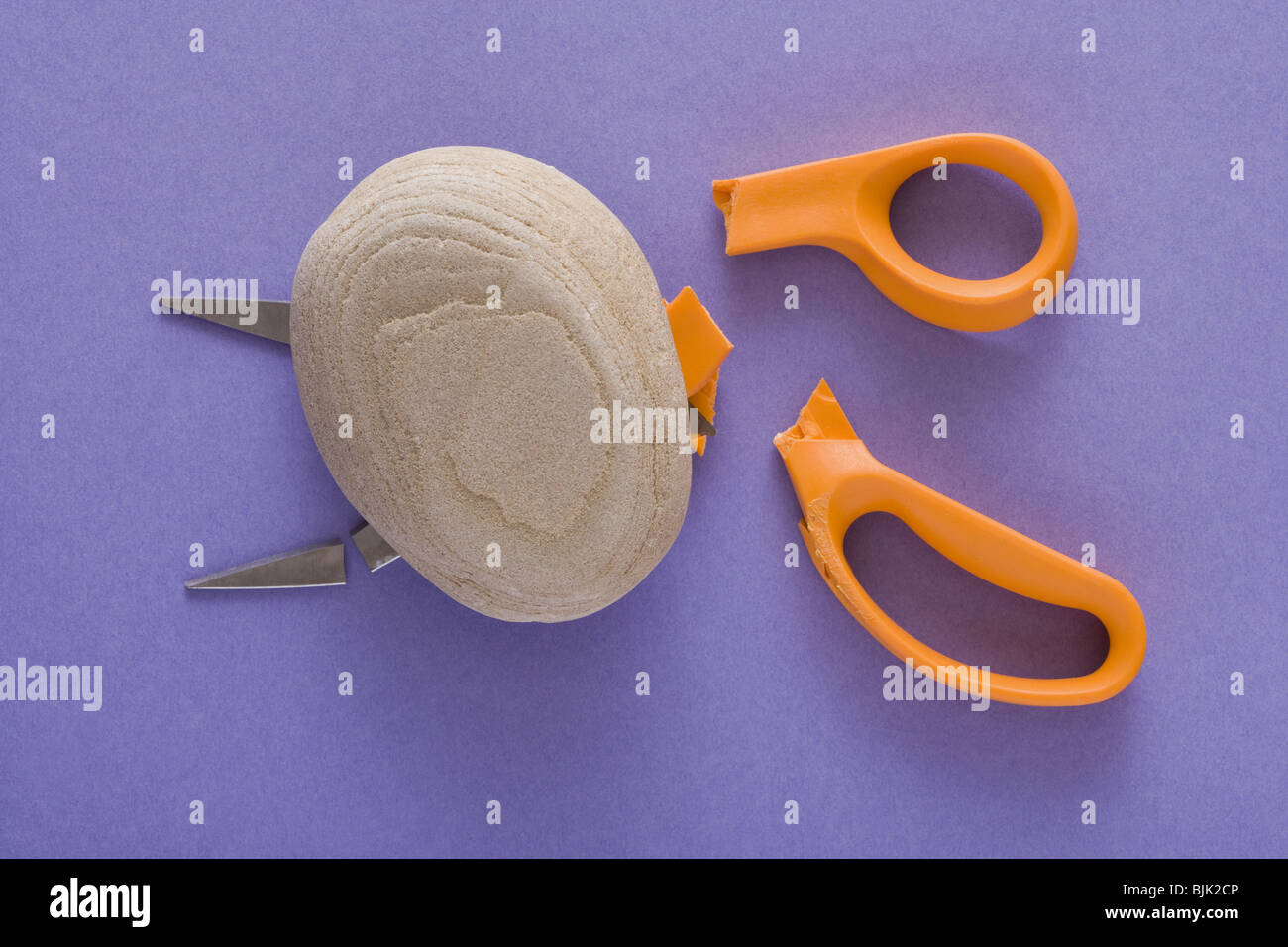 Rock with broken scissors Stock Photo - Alamy