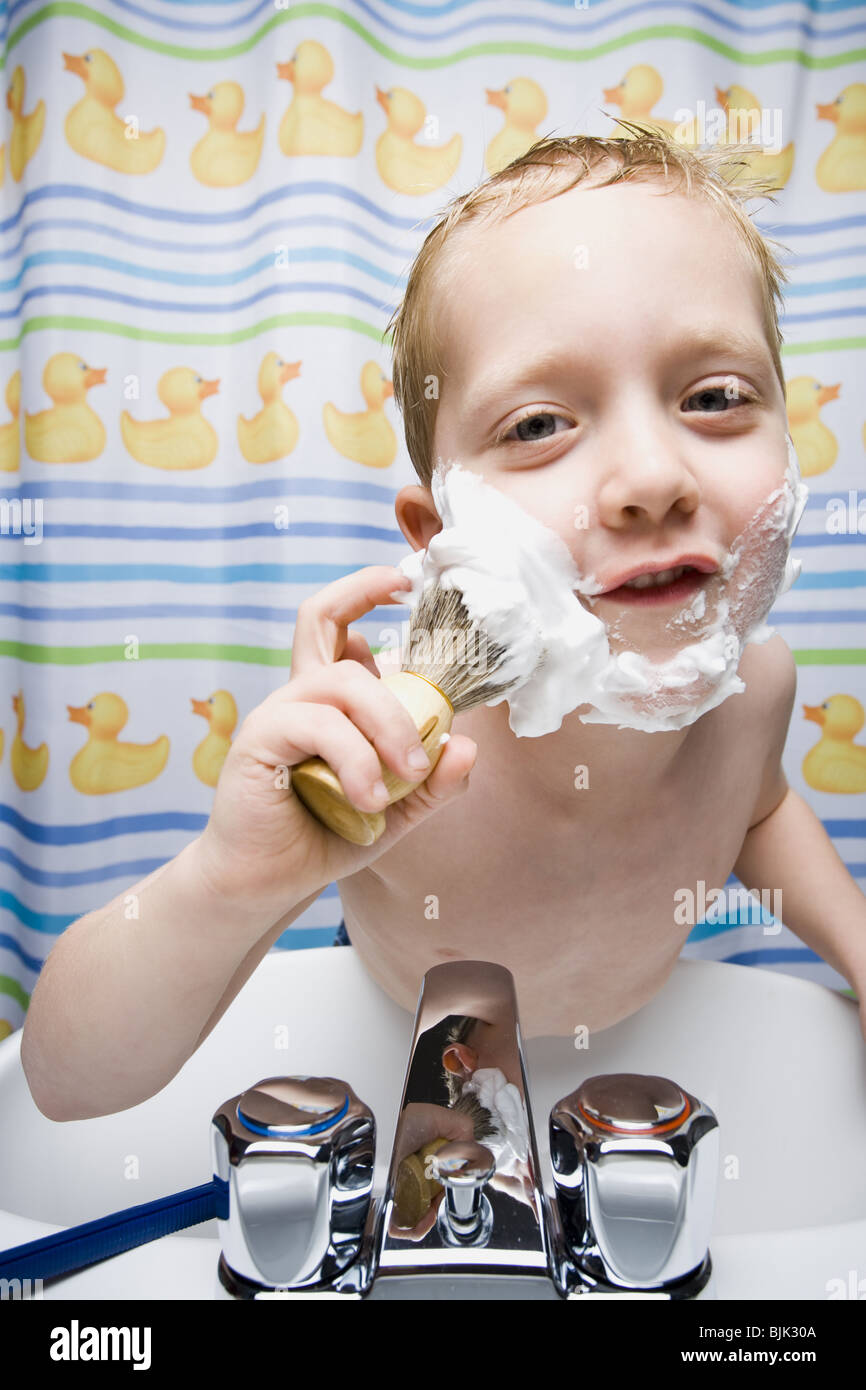 Boy shaving in bathroom and smiling Stock Photo - Alamy