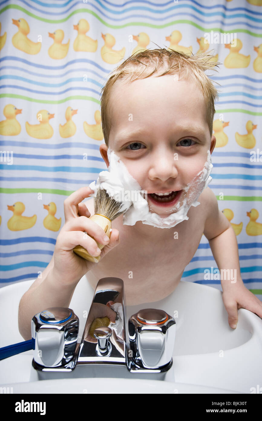 Boy shaving in bathroom and smiling Stock Photo - Alamy